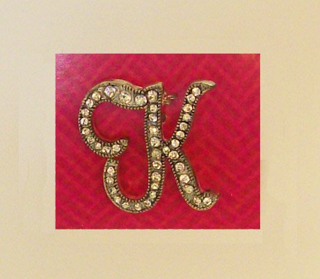 INITIAL K PIN. Silver in color with rhinestone accents.